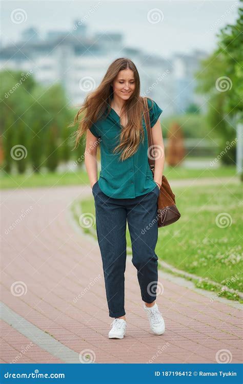 A Woman Wears Casual Clothes Walks Thrusting Hands Into Pockets Of