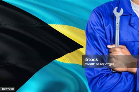 블루 유니폼에서 바하마 정비사는 바하마 플래그 배경을 흔들며에 대 한 렌치를 들고 있다 교차 무기 기술자 교통수단에 대한 스톡 사진 및 기타 이미지 Istock