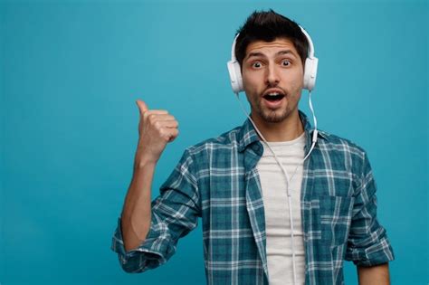 Premium Photo Impressed Young Man Wearing Headphones Looking At