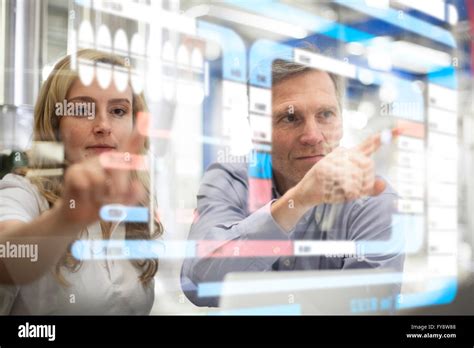 Man And Woman Using Transparent Touchscreen Device Stock Photo Alamy