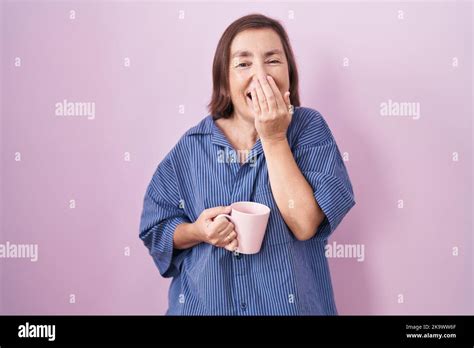 Middle Age Hispanic Woman Drinking A Cup Coffee Laughing And