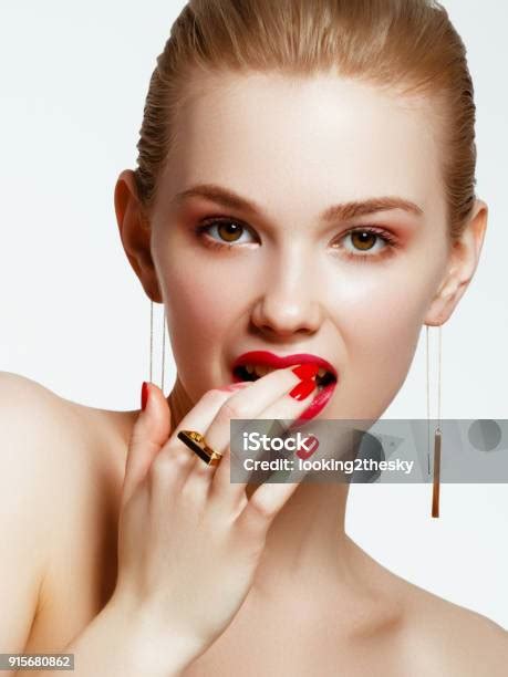 메이크업 제품입니다 골드 귀걸이와 반지 흰색 바탕에 웃 고 젊은 아름 다운 소녀 빨간 손톱 매니큐어와 하얀 미소입니다 패션 액세서리와 함께 젊은 여성 감정에 대한 스톡 사진