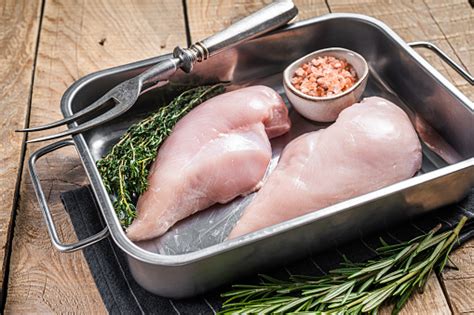 백리향과 로즈마리가있는 부엌 트레이에 생 닭 가슴살 필레 나무 배경 위쪽 보기 껍질이 없는 것에 대한 스톡 사진 및 기타 이미지
