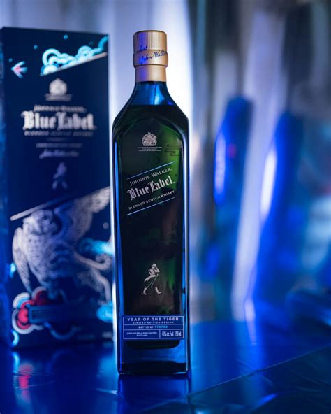 상자 옆 테이블에 있는 파란색 라벨 한 병 사진 Unsplash의 무료 알코올 이미지