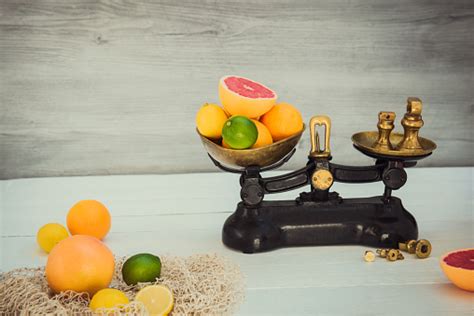 빈티지 무게와 여러 오렌지 레몬 자몽 흰색 나무 테이블에 라임의 하나의 비늘에 신선한 감귤류 해독 다이어트 수확 개념입니다 농부 시장 공간을 복사합니다 감귤류 과일에 대한