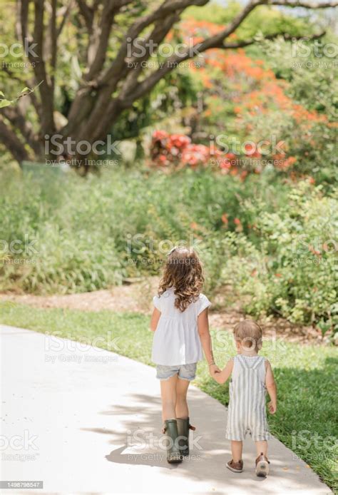 라이프 스타일 젊은 형제 자매가 함께 걷는 솔직한 순간 웨스트 팜 비치 플로리다 가든 쿠바 계 미국인 4 살짜리 유아 소녀 및 1 살짜리 아기 둘 다 갈색 머리에서 세이지