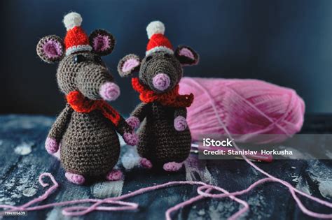 크리스마스 모자와 파란색 배경에 밝은 원사 Clews 근처에 서 있는 사랑스러운 수제 Amigurumi 쥐 새해 2020 개념
