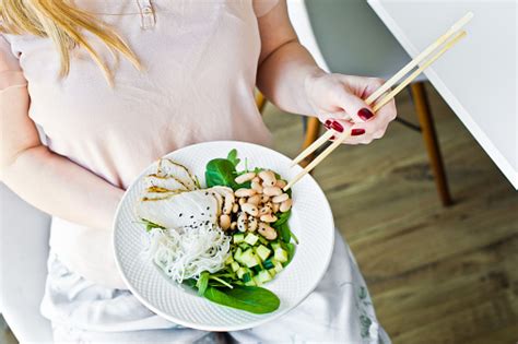 女孩拿著筷子 佛陀碗與玻璃麵條 豆類 雞胸肉 菠菜 芝麻和黃瓜白色背景頂部視圖文本空間 照片檔及更多 吃 照片 Istock