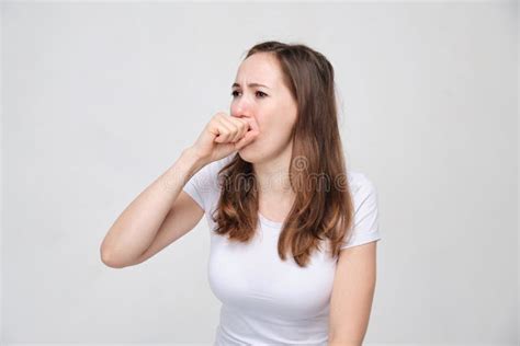 A Girl In A White Shirt Sneezes And Coughs From Colds And Flu Stock
