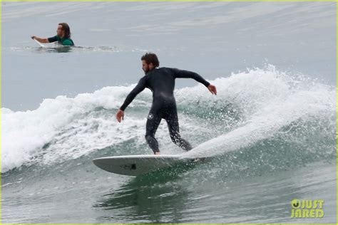 Liam Hemsworth Bares Ripped Abs While Stripping Out Of Wetsuit Photo