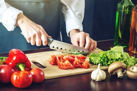 Premium Photo Chef In Black Apron Cutting Vegetables
