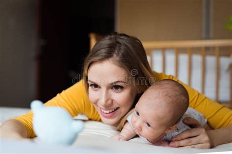 Madre Con Su Hijo Recién Nacido Del Bebé Que Miente En Cama Imagen De
