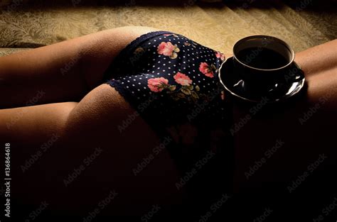 Dark Blue Cup Of Tea In A Saucer On The Sexy Body Of Slim Beautiful