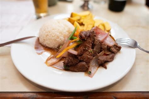 Premium Photo A Plate Of Lomo Saltado Typical Peruvian Food With Cutlery On The Table