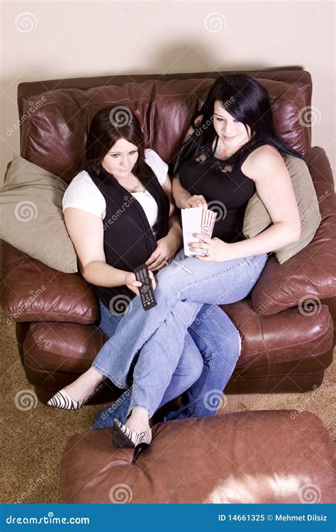 Two Girls Sitting On The Sofa Watching A Movie Stock Image Image Of