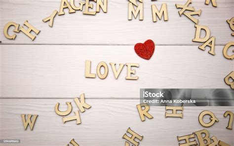 반짝이는 붉은 하트가 있는 밝은 나무 배경에 장식나무 글자로 만든 사랑이라는 단어 발렌타인 데이 포스터 인사말 카드 배너 0명에