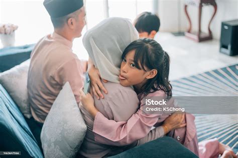 전통 의상을 입은 말레이 무슬림 아이들이 집에서 하리 라야를 축하하는 Aidilfitri 축하 말레이 가족 동안 부모에게