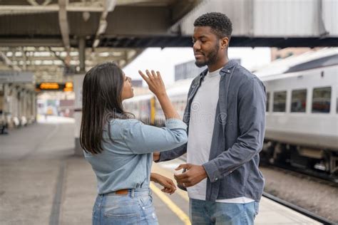 Cheerful Couple At A Railway Station Waiting For The Train On The