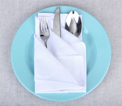 Premium Photo Folded Napkin With Fork Spoon And Knife On Plate On