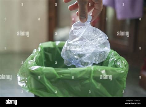 Man Hand View While Trashing Used Plastic Bottle On Separate Garbage
