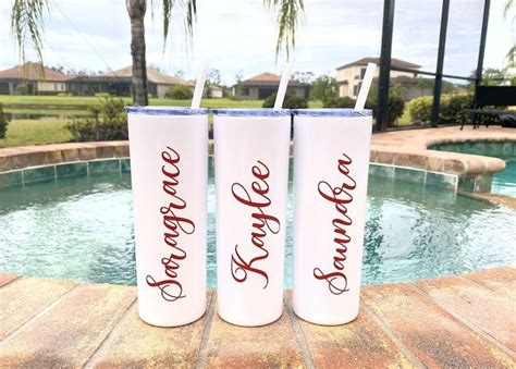Three Personalized Tumblers Sitting Next To A Pool