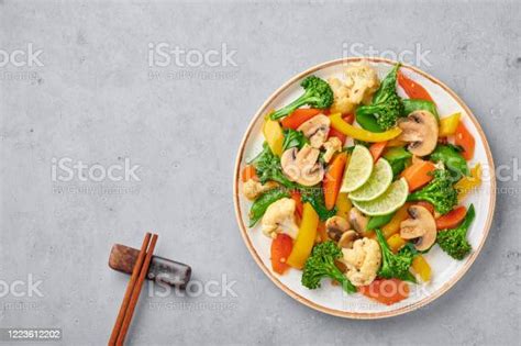 패드 박 루암 또는 회색 콘크리트 배경에 흰색 접시에 채식 볶음 야채 패드 팍 은 야채와 소스가 섞인 태국 요리 채식 요리입니다