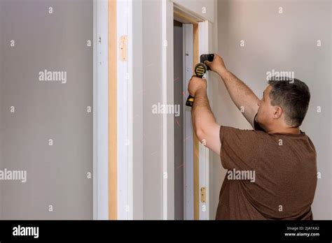 Installing The Door Hinge On The Door Frame Using A Screwdriver A Home Reconstruction Stock