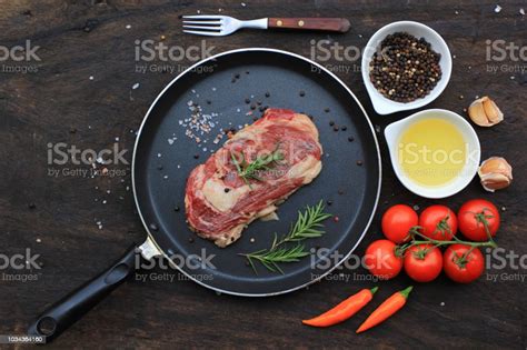 나무 어두운 배경 음식 고기 또는 바베 큐에 로즈마리 프라이팬에 야채와 원시 쇠고기 스테이크의 상위 뷰 스테이크에 대한 스톡