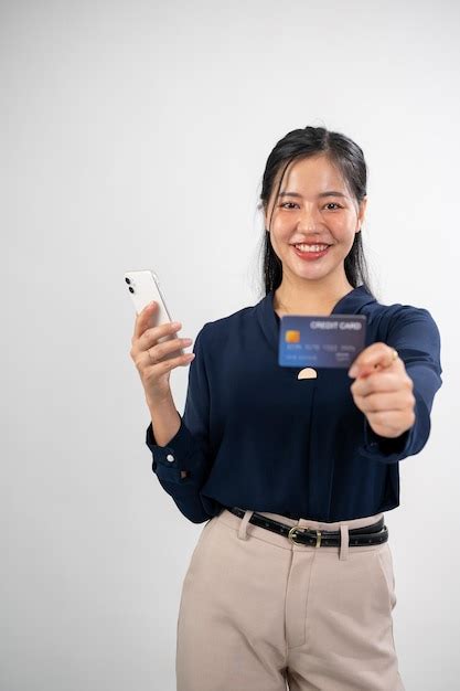 Premium Photo An Attractive Asian Woman Is Showing A Credit Card To