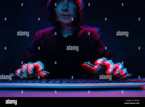 Hacker In The Hood Working With Computer Typing Text In Dark Room