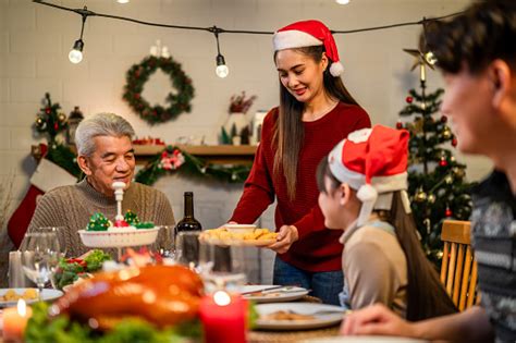 집에서 함께 크리스마스 파티를 축하하는 아시아 사랑스러운 가족 휴일 추수 감사절을 축하하기 위해 음식을 먹고 집에서 식탁에 크리스마스 이브를 먹는 매력적인 부모와 친척 12