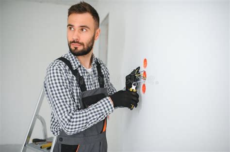 Electrician Builder At Work Installation Of Sockets And Switches