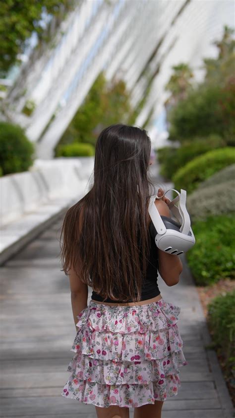 A Woman In A Summer Dress And Flowing Long Hair Is Strolling Along A