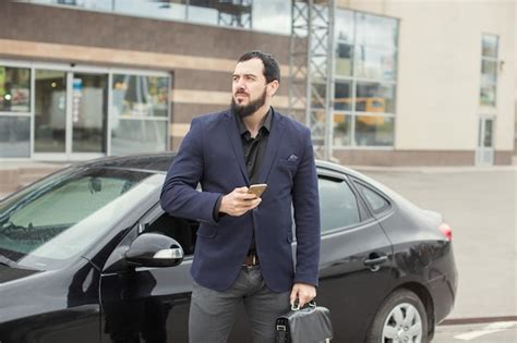 Premium Photo A Brunette Guy With A Beard Near A Black Car