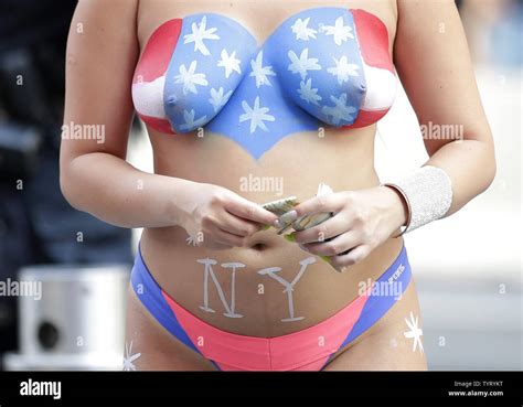 A Woman With American Flag Body Paint Covering Her Chest Holds Cash In