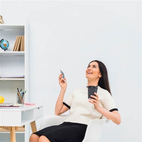 Free Photo Woman With Smartphone And Coffee Cup Laughing In Office