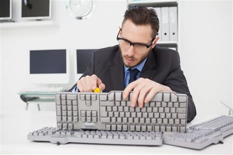 premium photo technician fixing keyboard with screw driver