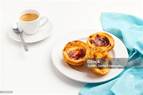 전통적인 포르투갈 에그 타르트 디저트 파스텔 드 나타 또는 흰색 바탕에 커피를 곁들인 파스테이스 드 벨렘 Egg Tart에 대한