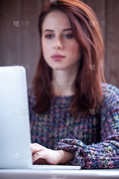美丽的年轻女子在美妙的木制背景上打字