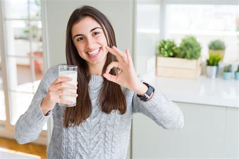 손가락으로 확인 기호를하고 신선한 우유 한 잔을 마시는 아름다운 젊은 여자 우수한 기호 가정 생활에 대한 스톡 사진 및 기타 이미지 가정 생활 개념 개념과 주제