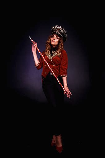 비누 거품을 보여주는 지팡이를 가진 서커스의 여성 마술사 환상 주의자는 검은 배경에 보여줍니다 극장 공연의 개념 무대 의상에