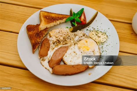 아침 식사로 토마토 오이 치즈를 곁들인 계란 튀김 카페에서 소시지와 토마토를 곁들인 스크램블 에그 계란 햄 야채 토스트와 함께