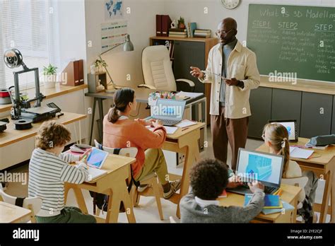 Teacher Instructing Students About 3d Modeling On Computers In