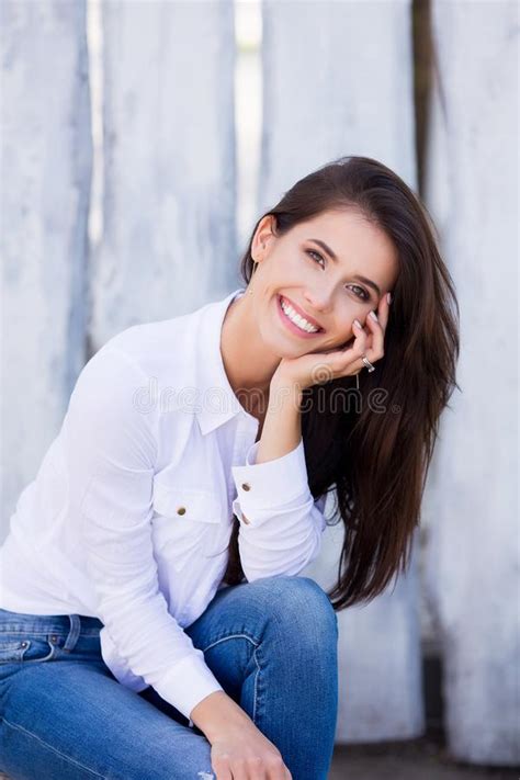 Muchacha Sonriente Hermosa Que Lleva La Camisa Blanca En Blanco Y