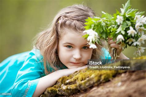 봄 나무에서 걷는 파란 드레스에 아름 다운 어린 소녀 예쁜 소녀는 텀블 다운 나무에 리 잉 여름에 야외에서 노는 아이 부활절 시간입니다 갈란투스에 대한 스톡 사진 및 기타