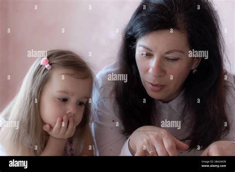 Grandmother With Grandson And Granddaughter In Bed Reading A Book