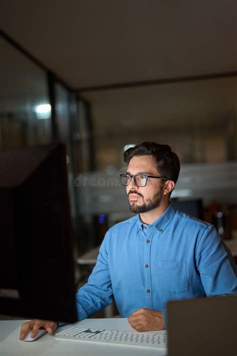 Busy Young Business Man Using Computer Working Late In Office Vertical