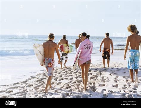 Rear View Of People Walking With Surfboards On Beach Stock Photo Alamy