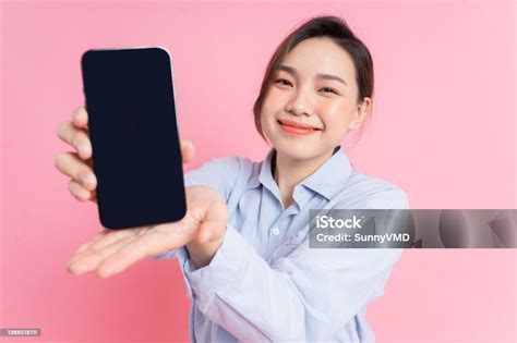 ピンクの背景にスマートフォンを持っている若いアジアの女の子の画像 女性一人のストックフォトや画像を多数ご用意 女性一人 1人