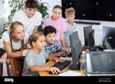 Computer Lesson In Classroom Classmates Solve Problems On Computer